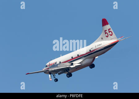 Lockheed L-188 Electra water bomber in flight to drop load on BC forewt ...