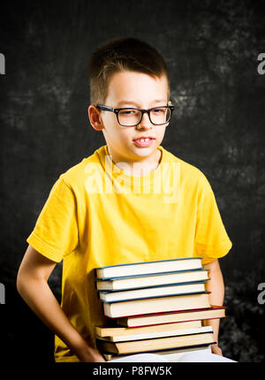 School kid lifting big pile of heavy books Stock Photo - Alamy