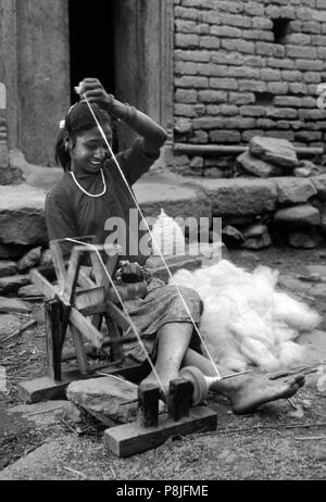 A Nepali woman spinning wool thread by hand in the medieval Newari ...