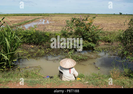 a women is fishing at a water Khmer Management System and canal in the ...