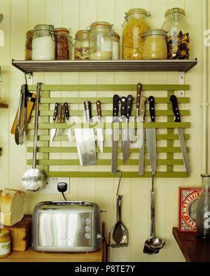 Glass shelving above stainless steel fitted units in modern kitchen ...