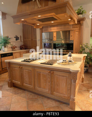 Large extractor above hob in island unit with black granite worktop in ...