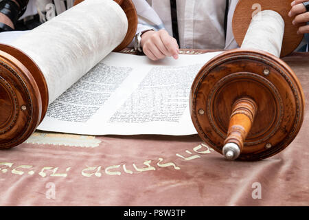 Reading a Torah scroll during a bar mitzvah ceremony with a traditional ...