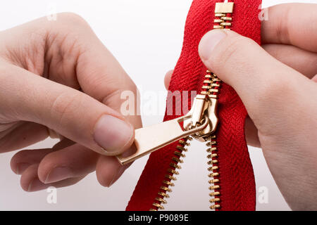 Hand holding color zipper on a white background Stock Photo - Alamy