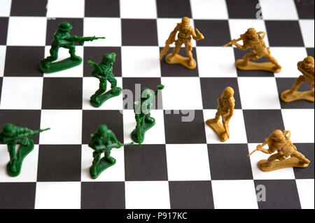 two armies of plastic toy soldiers facing each other on a checkerboard ...