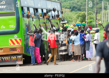 Kamdini, Uganda - At a bus stop, flying merchants offer travelers a ...