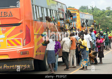 Kamdini, Uganda - At a bus stop, flying merchants offer travelers a ...