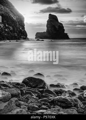 Evening Bay. Sharp rocks, black rounded boulders, stony beach, sand and ...