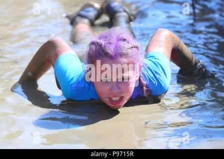A young girl crawls through sludge during the Young Mudders Obstacle ...