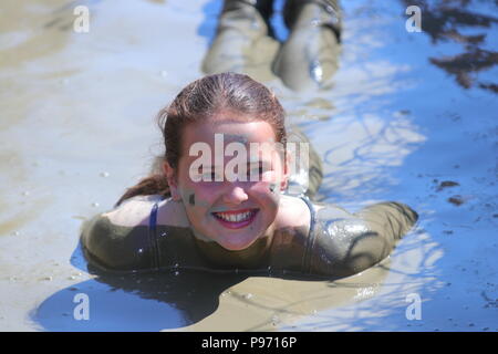 A young girl crawls through sludge during the Young Mudders Obstacle ...