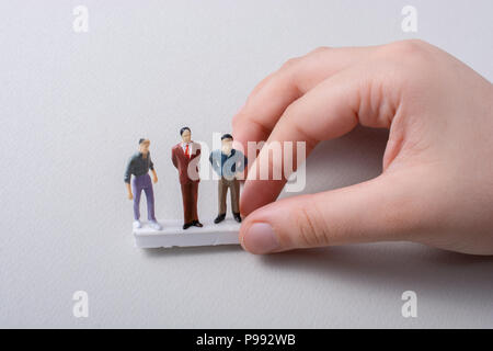 Tiny figurine of man miniature model in hand Stock Photo - Alamy
