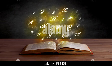 Glowing yellow alphabet letters coming out of an open book Stock Photo ...