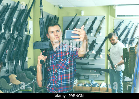 Guy taking selfie with rifle Stock Photo - Alamy