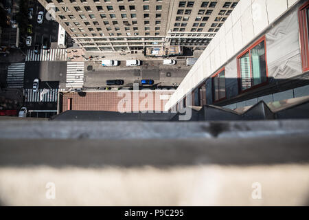 Downwards view from the ledge of a building in New York City with ...