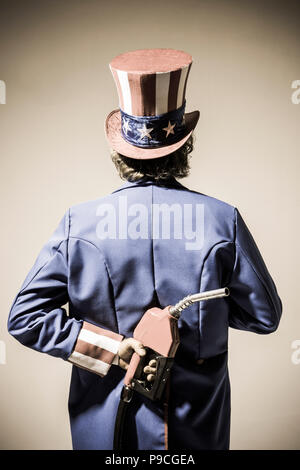 Uncle Sam character as seen from behind holding a gasoline pump nozzle ...