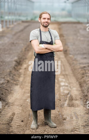 Farmer cultivating land in the garden with hand tools. Soil loosening ...