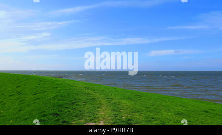 Green grass covered dike in Dutch fishing village Stock Photo - Alamy