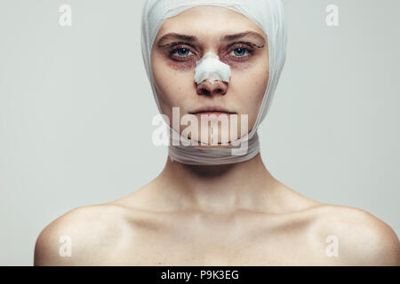 a woman with her head wrapped in a bandage Stock Photo - Alamy
