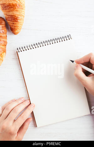 Woman's hand writing in a notebook with a pom-pom pen Stock Photo - Alamy