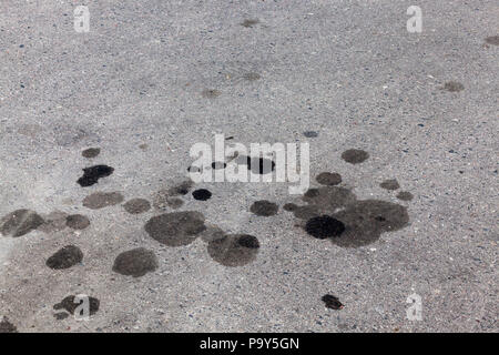 Oil spots on wet Tarmac road forming rainbow interference patterns ...