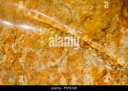 A riverbed of orange coloured sedimentary rock with beautiful patterns ...