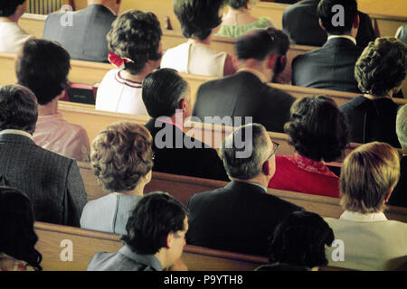 Rear view of seated congregation in UK church, seen through the windows ...