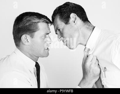 1960s PORTRAIT OF TWO BUSINESSMEN HEAD TO HEAD FIGHTING FISTS RAISED ...
