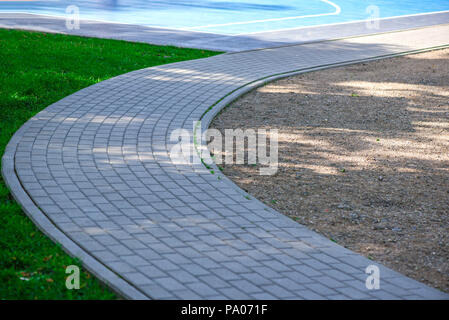 Newly made pathway, fence and gates to outdoor basketball court in park ...