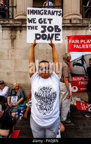 A protestor holds a sign during a pro-migrant rally, demanding an end ...