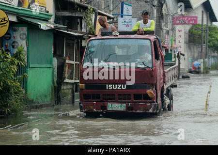 Bulacan, Philippines. 20th July, 2018. Students share an umbrella in ...