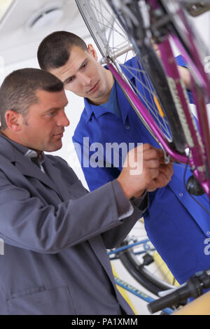 Mechanics working on bicycle brakes Stock Photo - Alamy