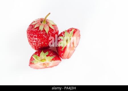 Close up of one cut strawberry on a pile of fresh ripe strawberries ...