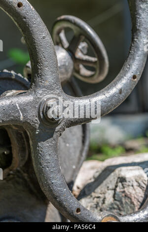 Old rustic farm equipment -- metal mechanical industrial worn wheel ...