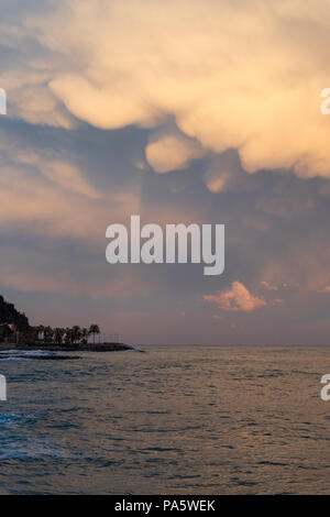 Dramatic colorful clouds at sunset hovering over the sea Stock Photo ...