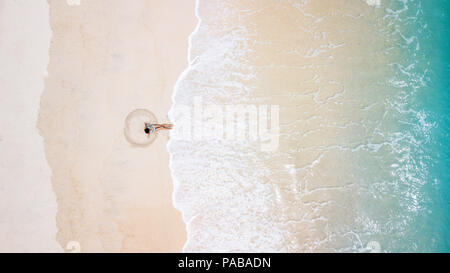 Girl making angel in sand on beach, high angle view Stock Photo - Alamy