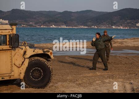 U.S. Navy sailor BM3 Kiana Martin Del Campo, Naval Beach Unit 7, guides ...