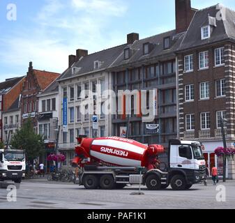 Heavy machinery and cement mixer trucks working together to load ...