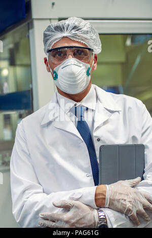Male scientist standing with arms crossed in laboratory Stock Photo - Alamy