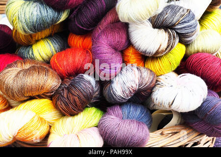 Selection of different coloured wool yarn on display on a wall in ...