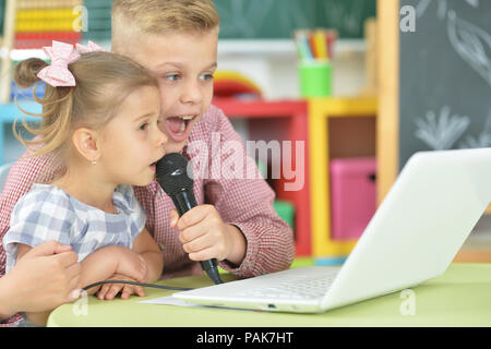 Brother and sister singing karaoke with laptop at home Stock Photo - Alamy