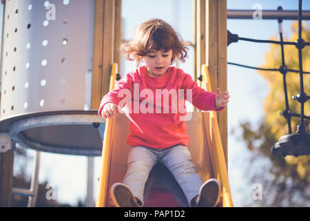 Little girl sliding down head first Stock Photo - Alamy