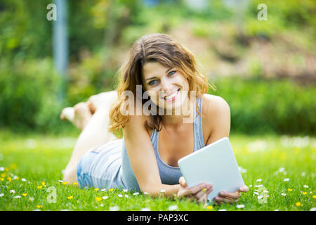 Smiling young woman with her ebook reading on the terrace Stock Photo ...