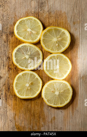 Close up of some lemons on a chopping board on a kitchen countertop ...
