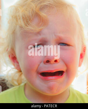 Crying child with curly red hair Stock Photo - Alamy