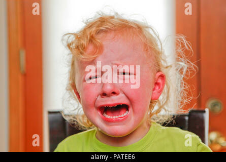 Crying child with curly red hair Stock Photo - Alamy