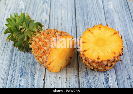 two halves of pineapple, cuteed ripe pineapple on light wooden ...