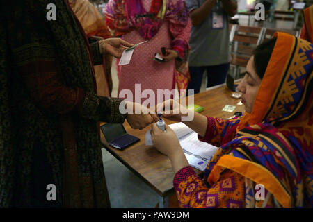 An official marks a voter's thumb at a polling center during the 12th ...