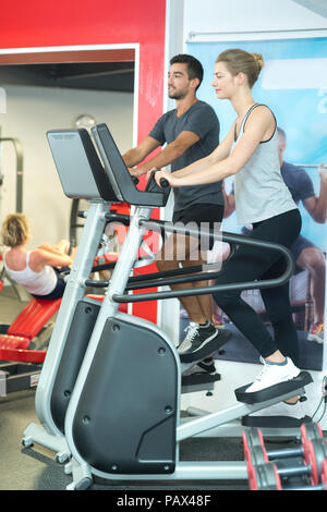 Sporty young man using step machine in gym Stock Photo - Alamy