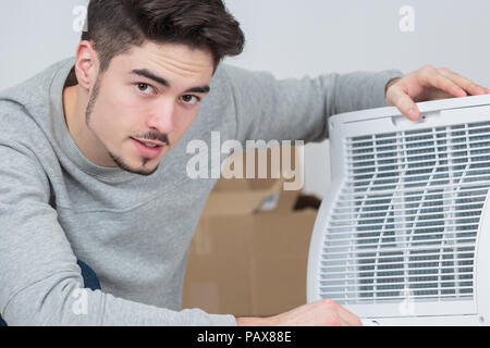 handsome young man electrician installing air conditioning in client ...