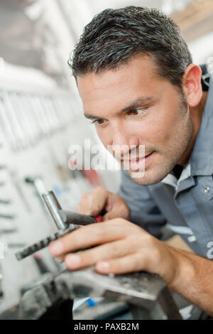 Mechanic filing spindle of cog Stock Photo - Alamy